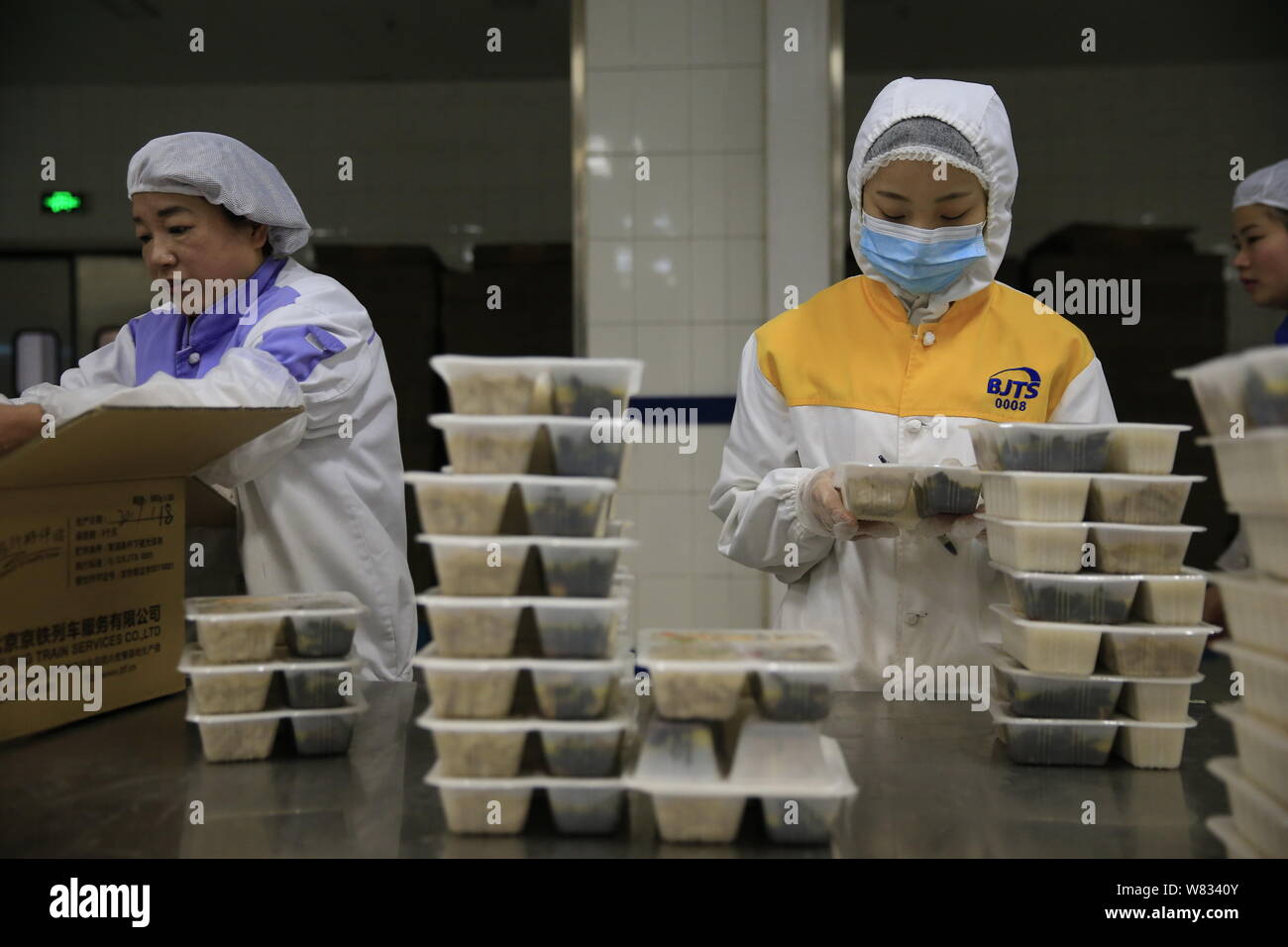 A Chinese worker checks food-filled lunch boxes of high-speed train ...