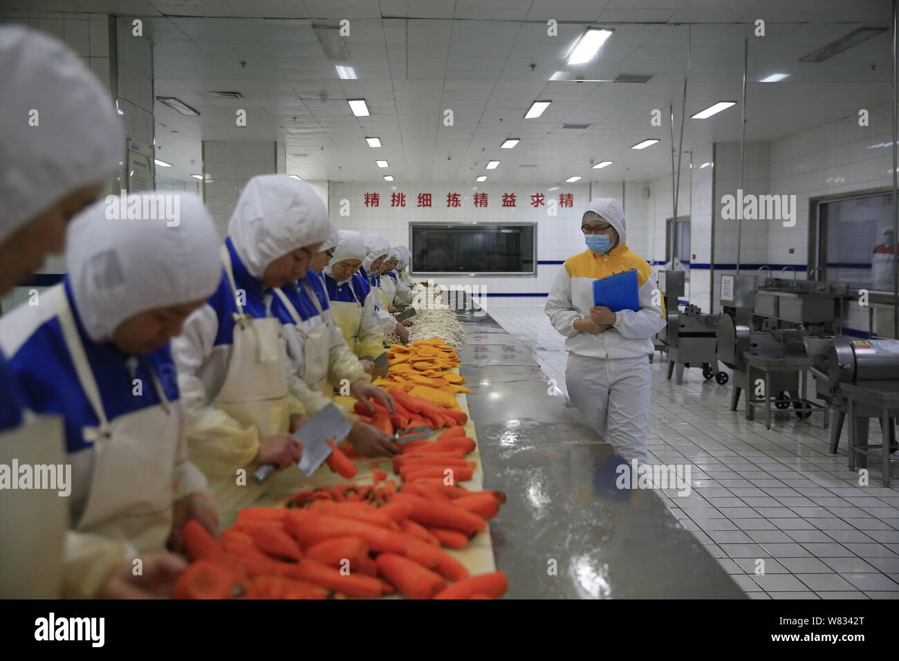 Chinese workers prepare ingredients for high-speed train meals at a ...