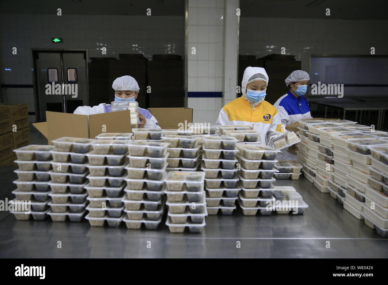 A Chinese worker checks food-filled lunch boxes of high-speed train ...