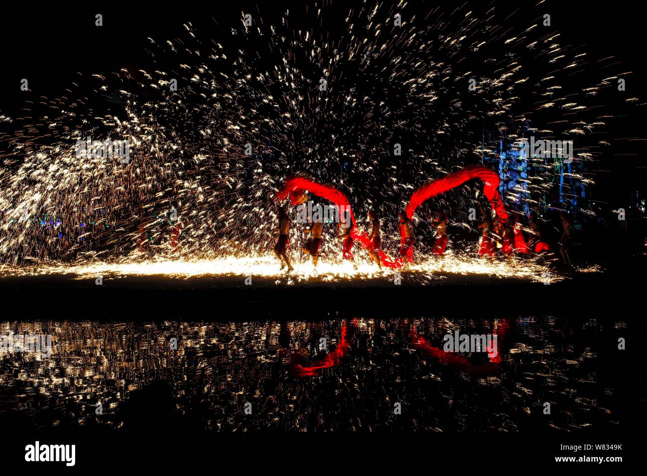 Chinese entertainers perform a fire dragon dance in a shower of molten ...