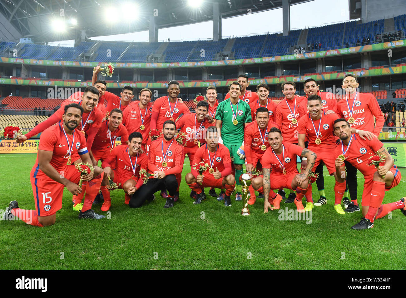 Players of Chile pose for photos with their trophy after defeating ...