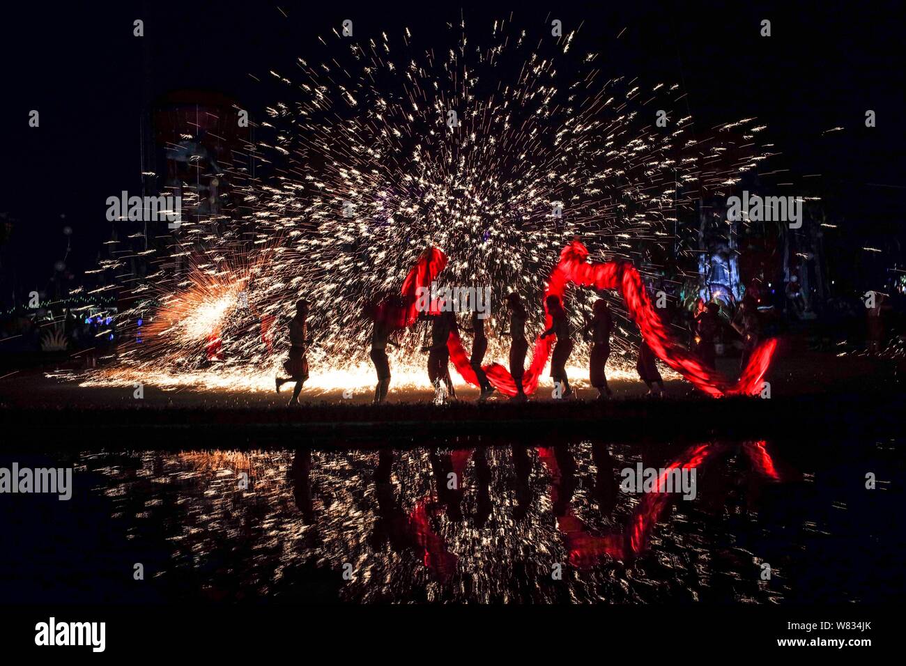 Chinese entertainers perform a fire dragon dance in a shower of molten ...