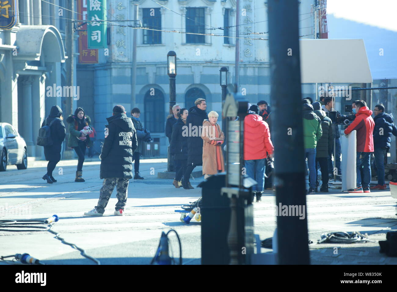 English actor Orlando Bloom, center, warms his hands up with a hand ...