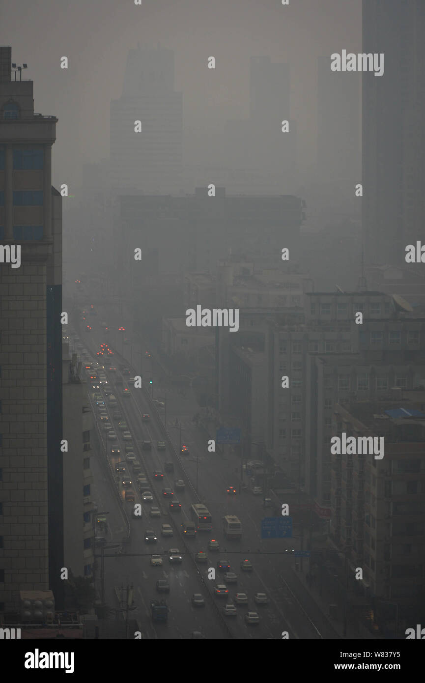 Masses of vehicles movely slowly on a road in heavy smog in Chengdu ...