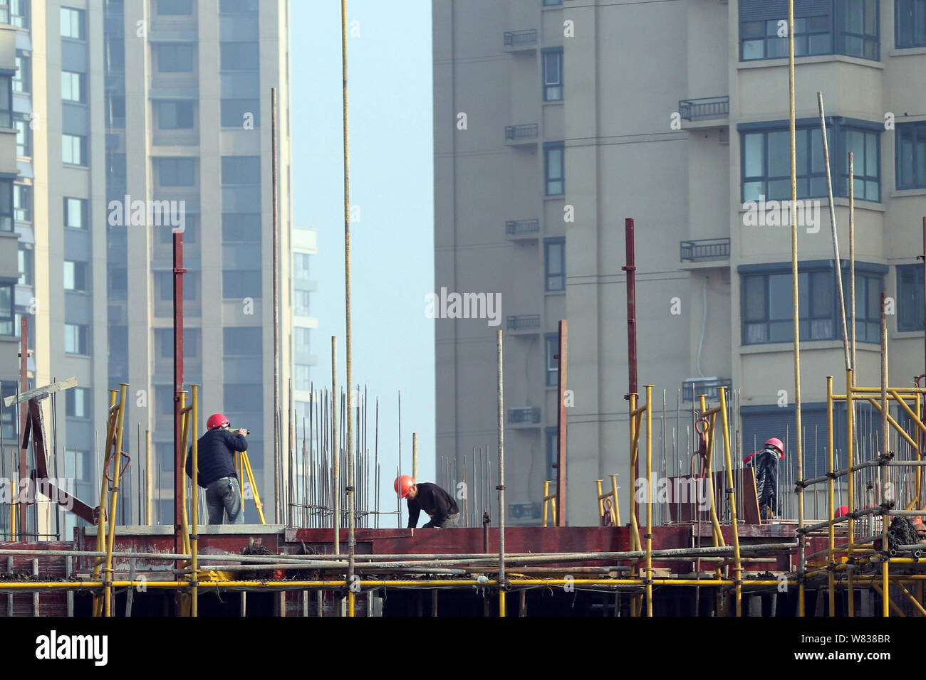 Chinese migrant workers construct a high-rise apartment building at the ...