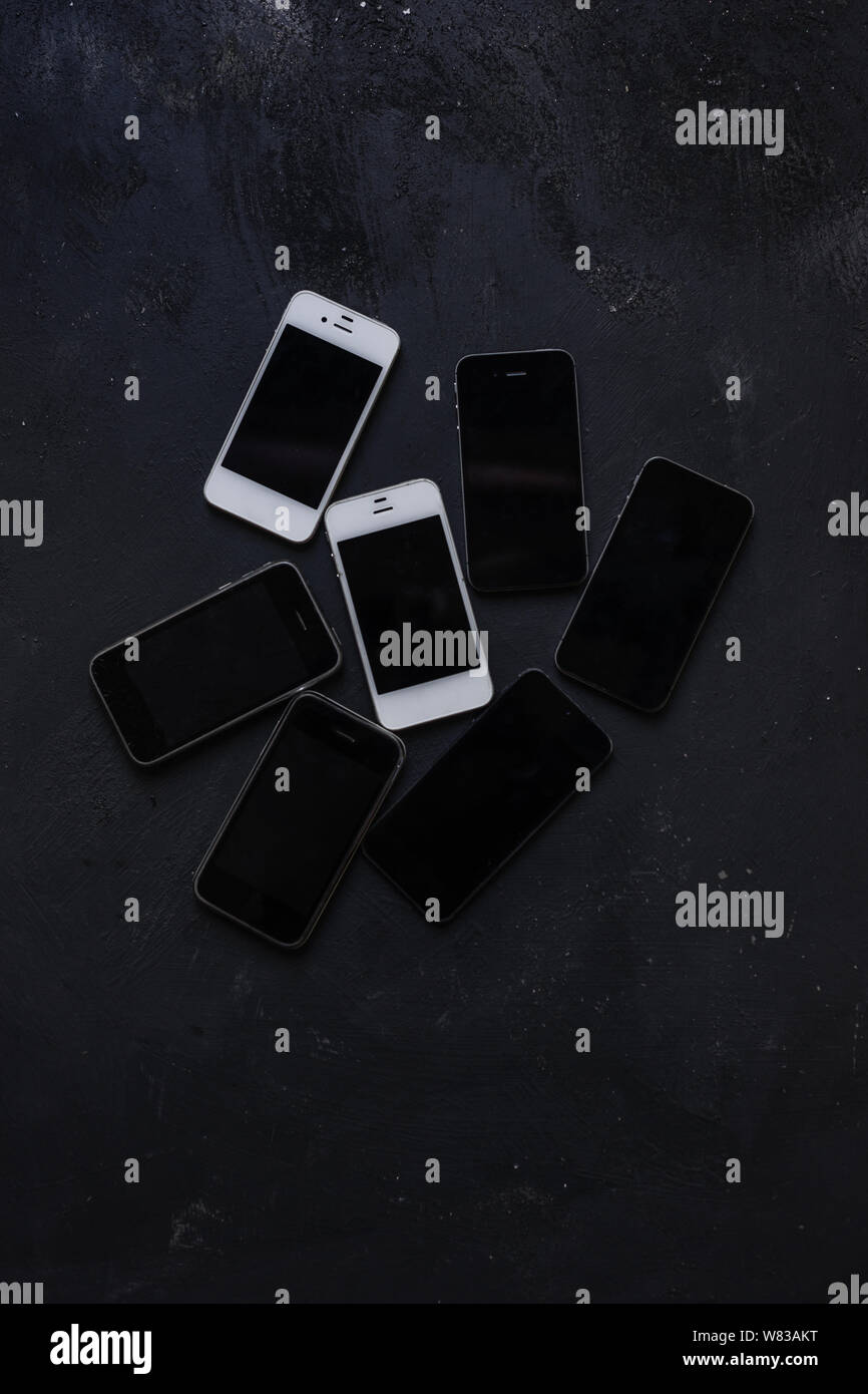 collection of old phones on black background, obsolete cracked ...