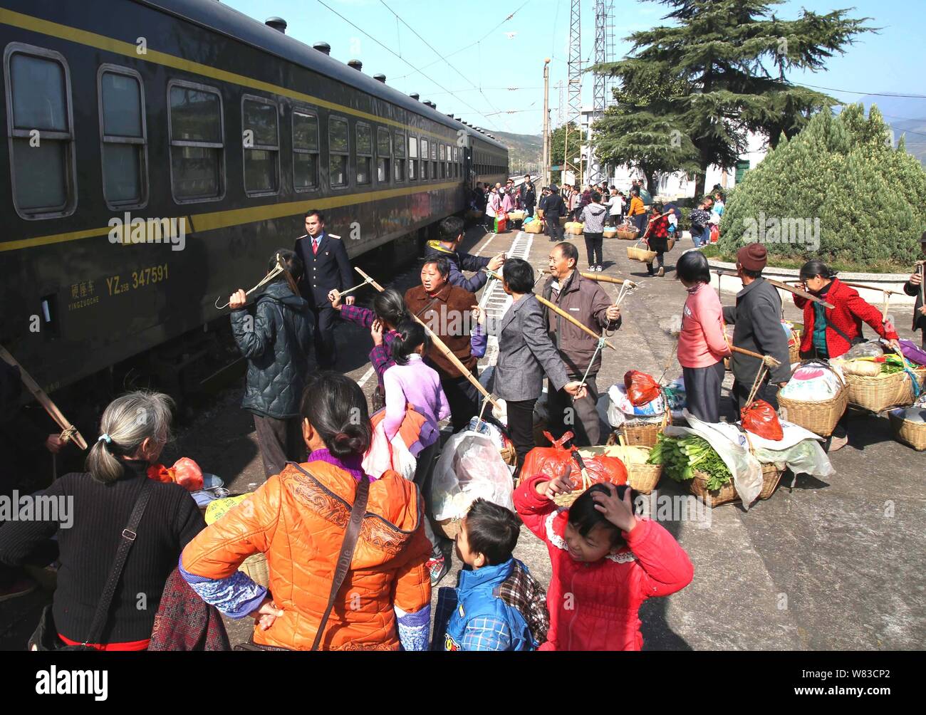 Chinese farmers carrying baskets of vegetables queue up to board a ...