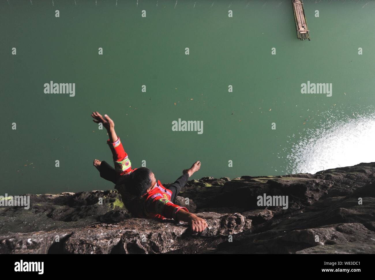 Chinese man Huang Xiaobao of Miao ethnic minority climbs the cliff in a ...