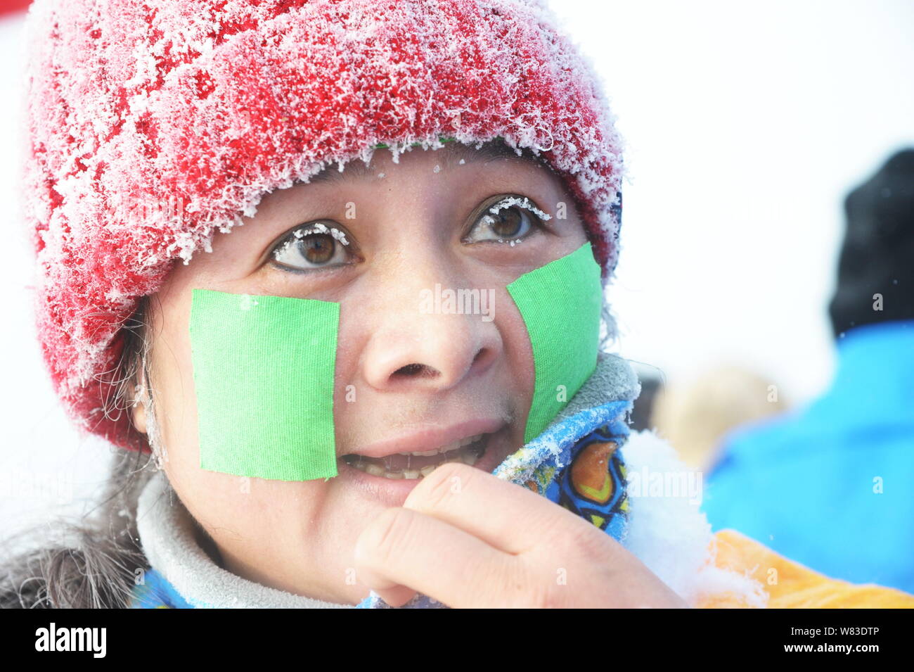 Ice, snow and frost are seen on the hat, eyebrows and eyelashes of a ...