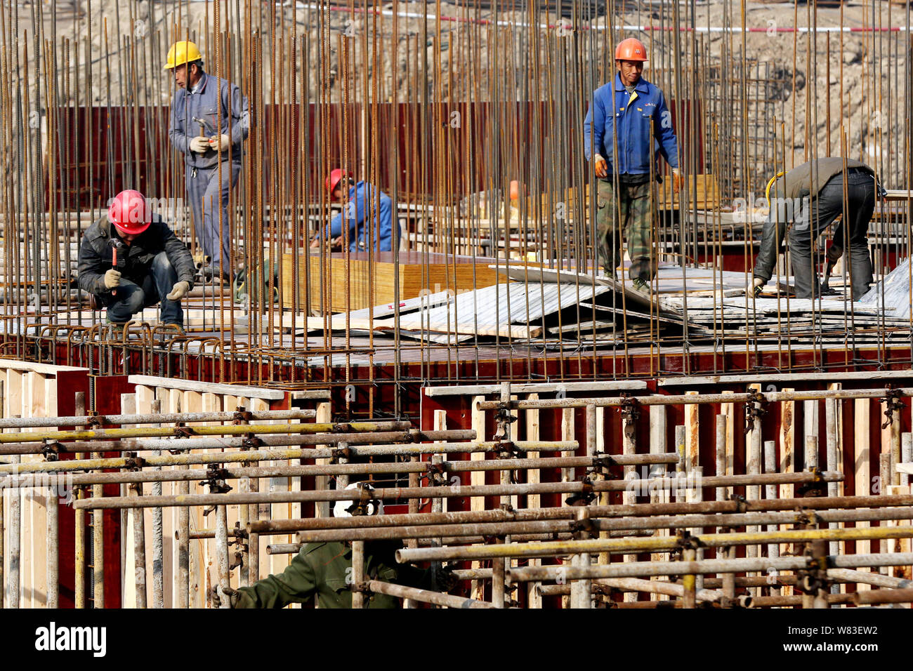 Chinese migrant workers construct a high-rise apartment building at the ...