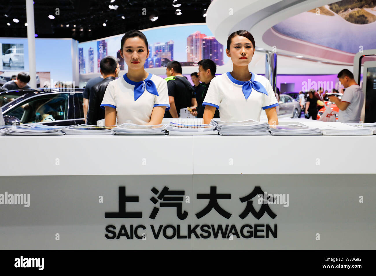 --FILE--Chinese employees are seen at the stand of SAIC Volkswagen, a ...