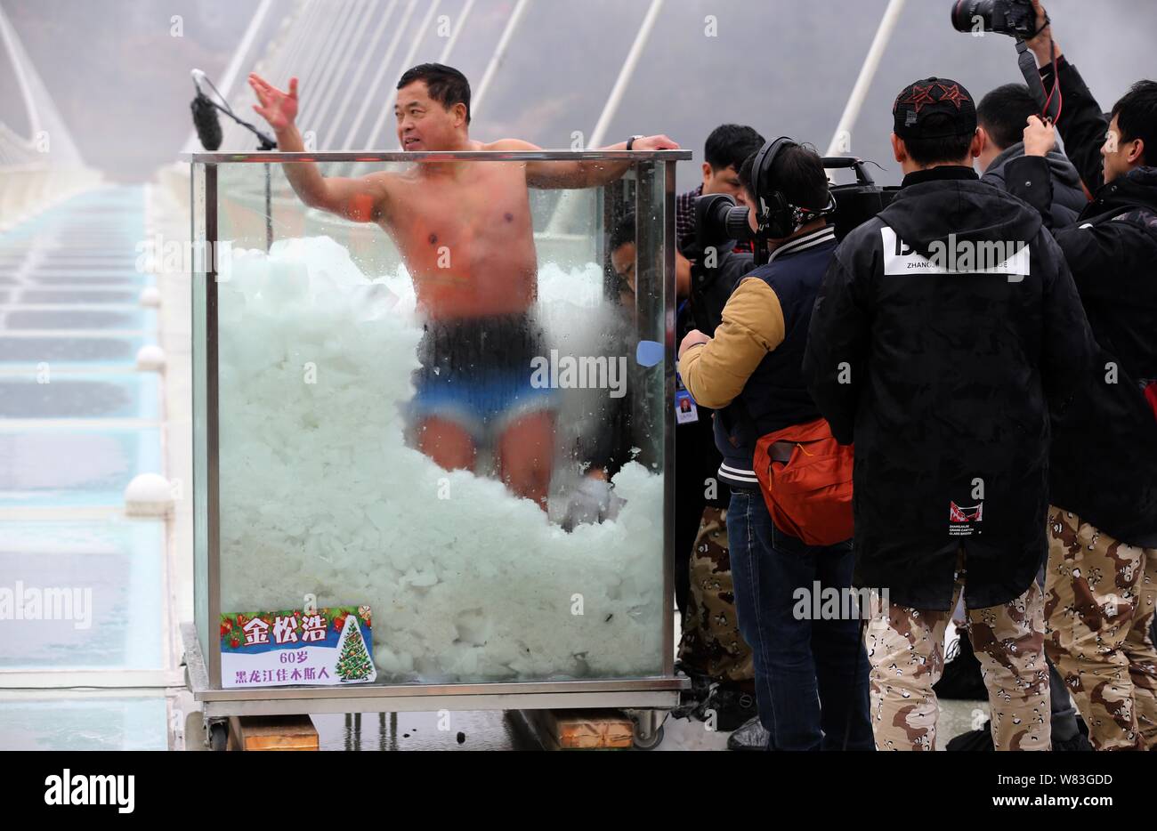 Chinese participant Jin Songhao stands up in a box filled with ice ...