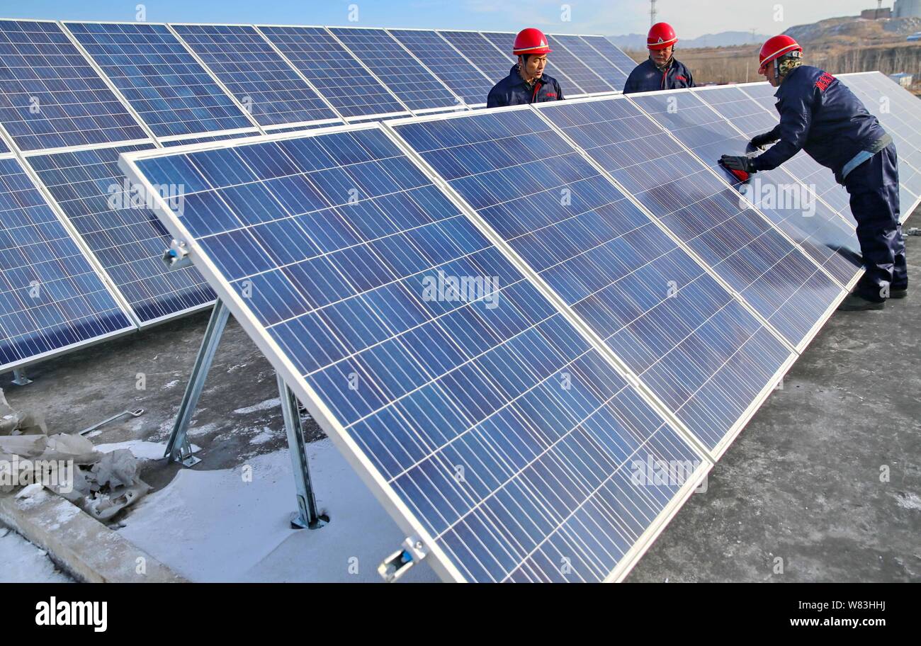 --FILE--Chinese workers install solar panels on the rooftop of a ...