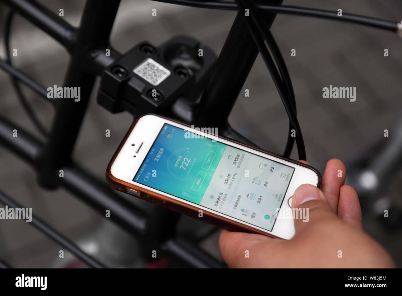 A Chinese mobile phone user scans the QR code on the bicycle of bike ...