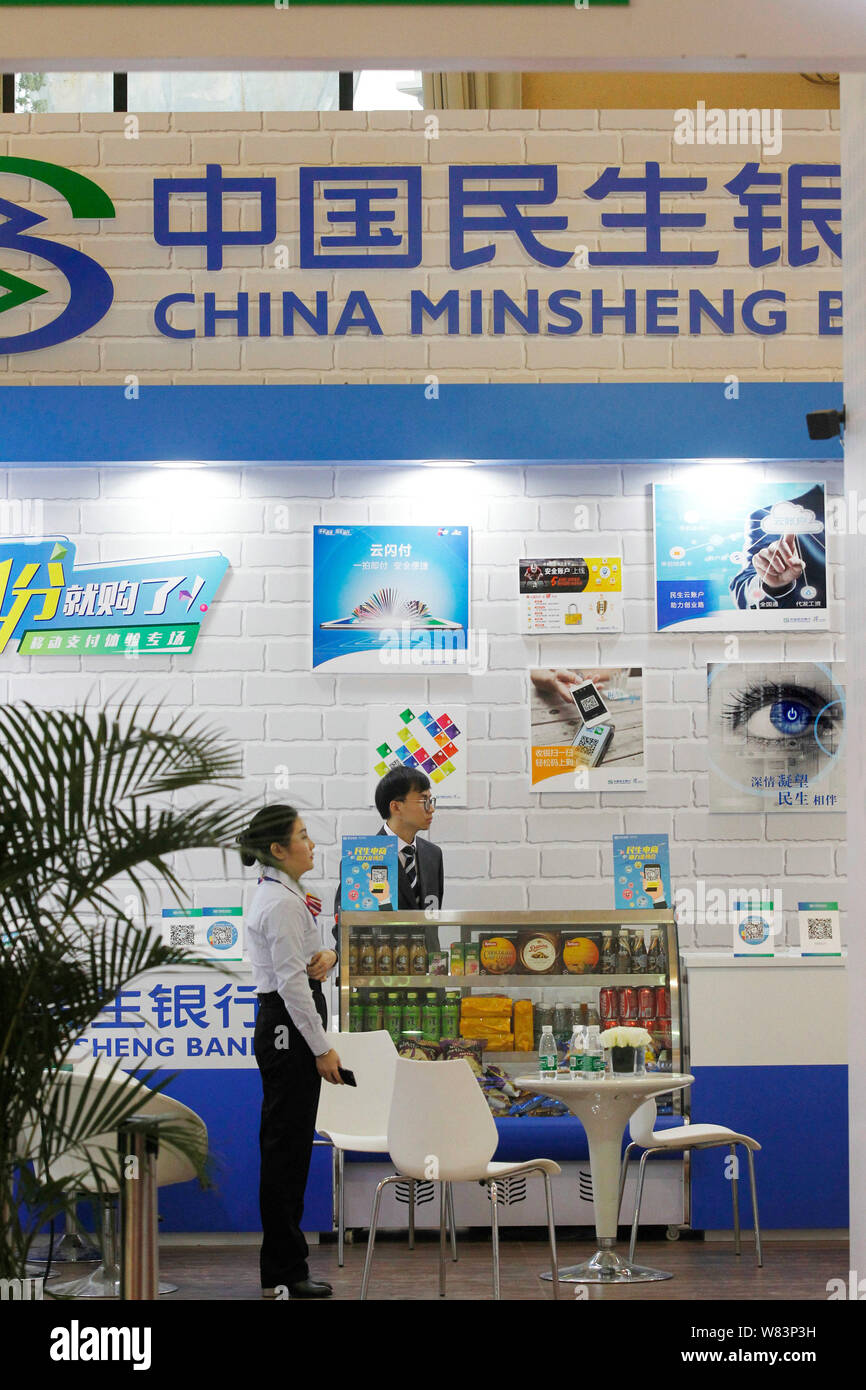 --FILE--Chinese employees are seen at the stand of China Minsheng Bank ...
