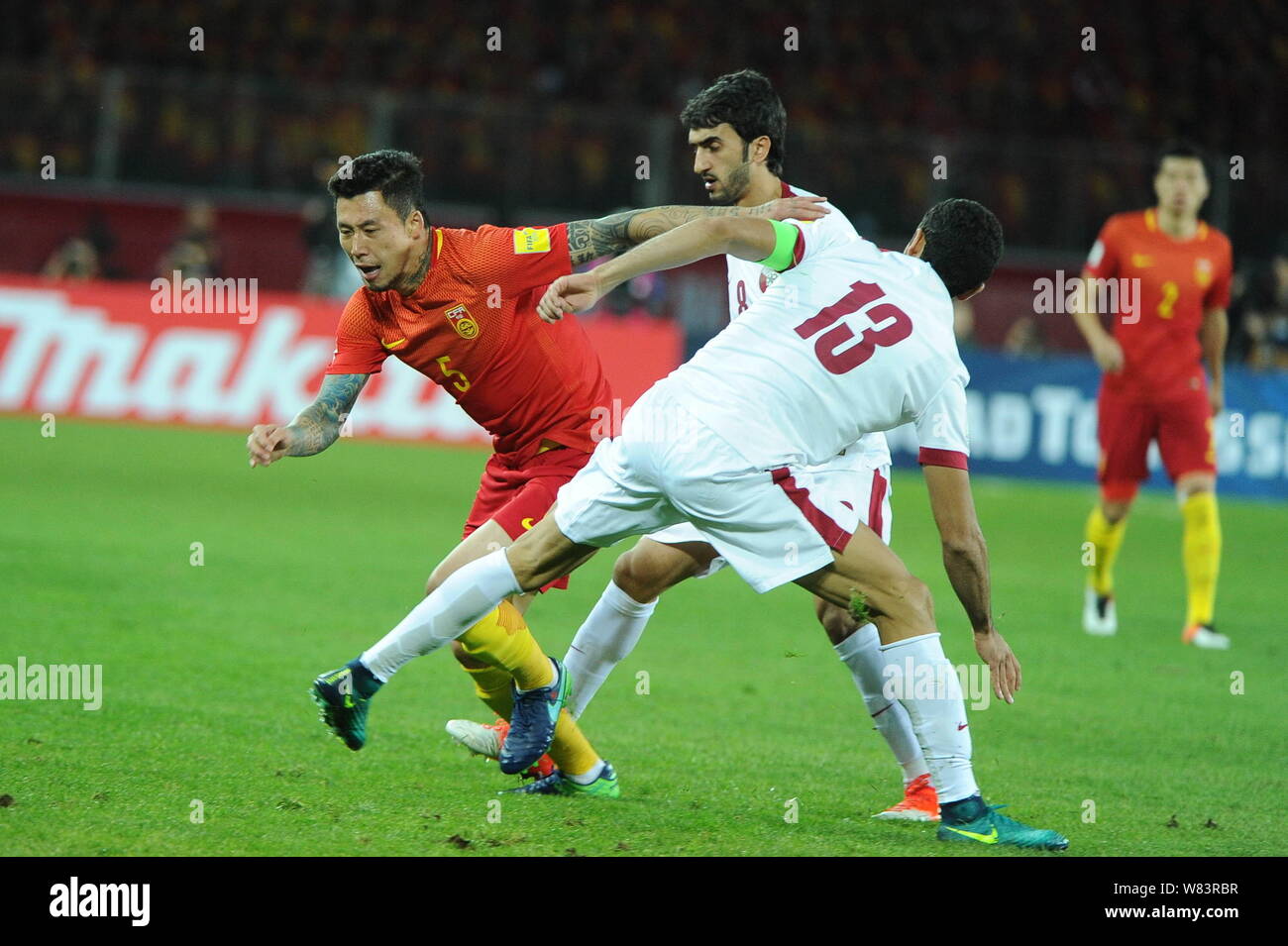Zhang Linpeng of China, left, challenges players of Qatar in their ...
