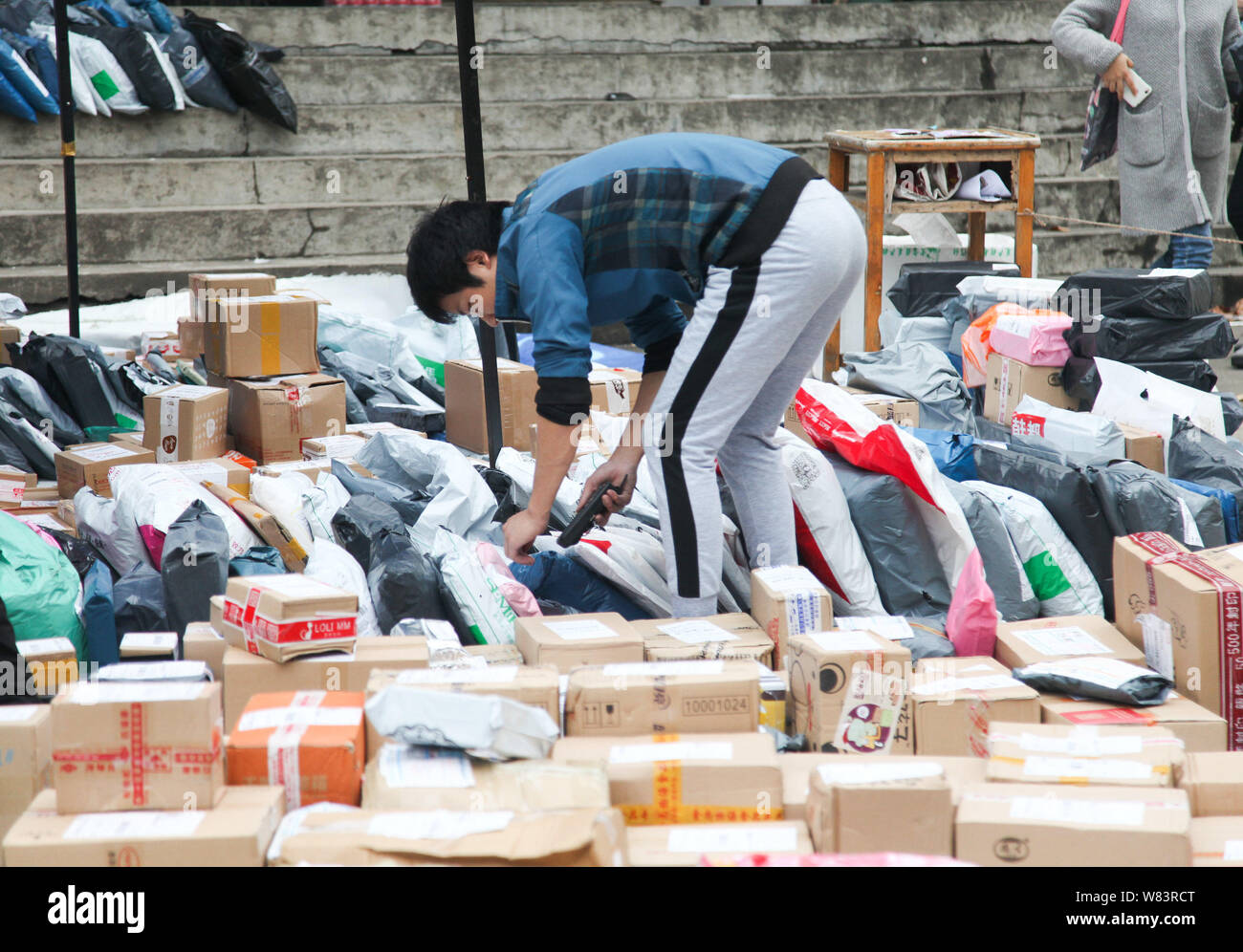 A Chinese courier scans the barcodes of parcels, most of which are from ...