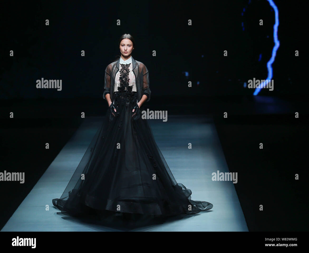 A model displays a new creation at a fashion show of AM.IXAM by Ying Ma during the China Fashion ...