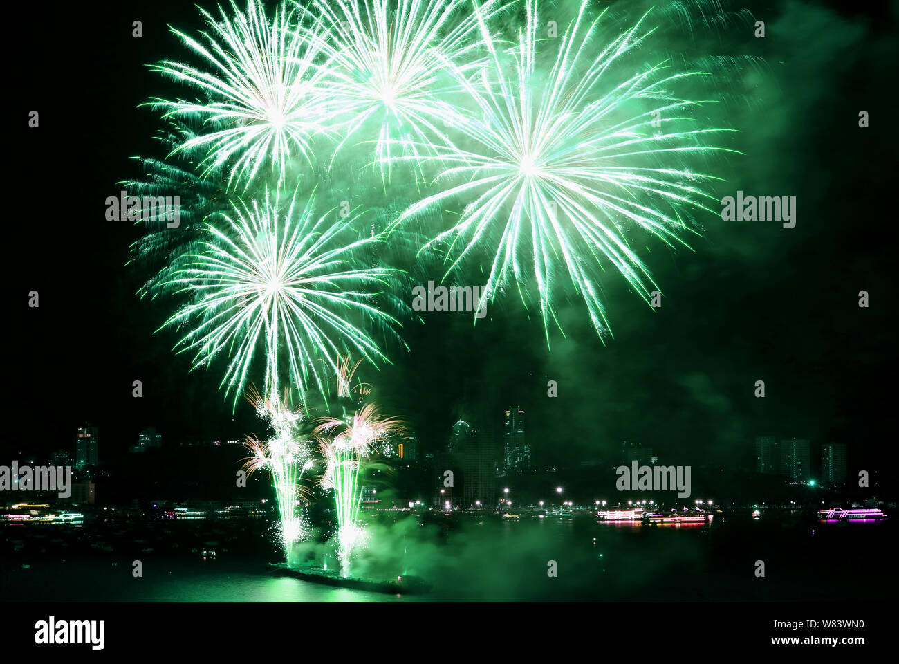 Stunning bright green color fireworks exploding in to the night sky ...