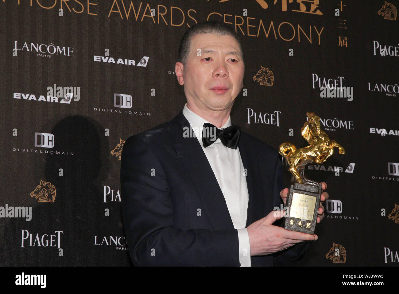 Chinese director Feng Xiaogang poses with his trophy of the Best ...