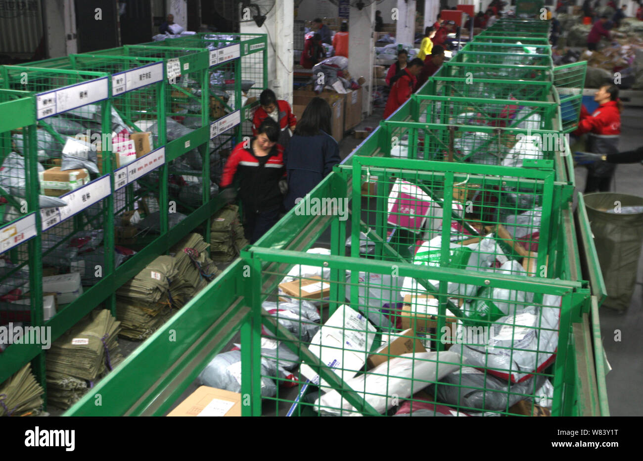 Chinese workers sort piles of parcels, most of which are from Singles ...