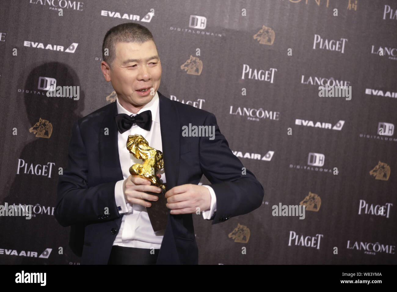 Chinese director Feng Xiaogang kisses his trophy of the Best Director ...