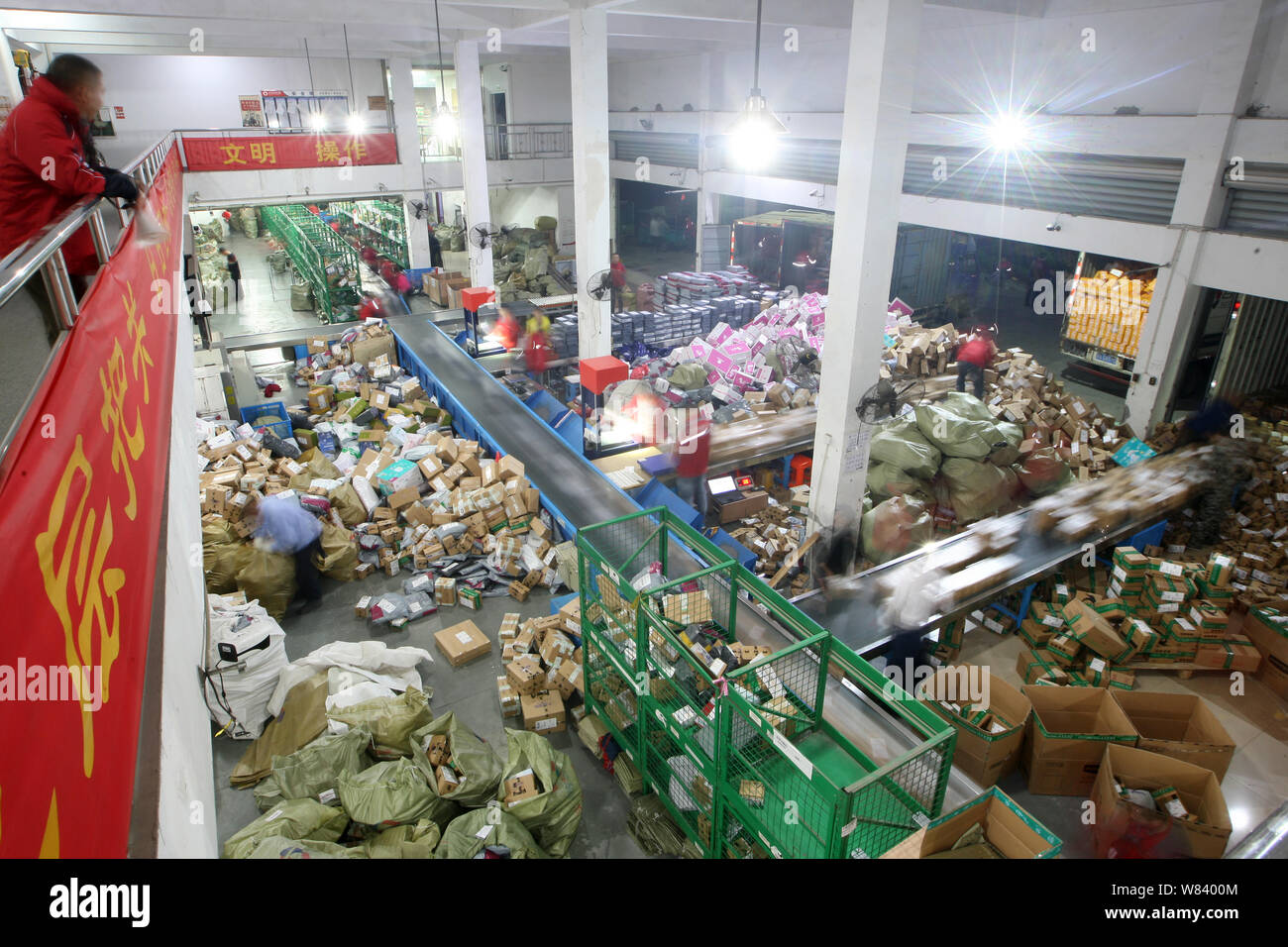 Chinese workers sort piles of parcels, most of which are from Singles ...