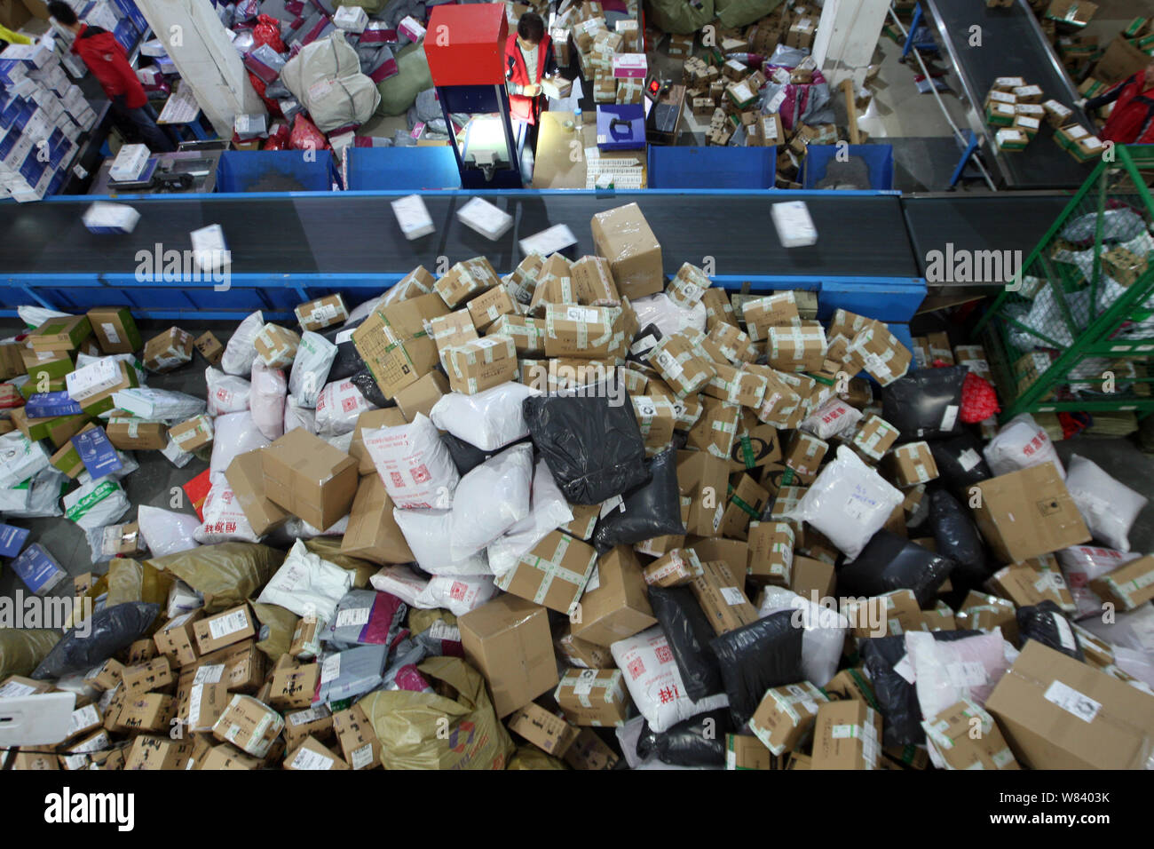 Chinese workers sort piles of parcels, most of which are from Singles ...