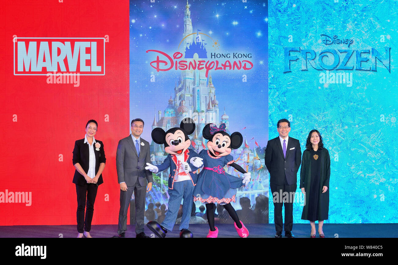 Executives and entertainers dressed in costumes of Micky Mouse and ...