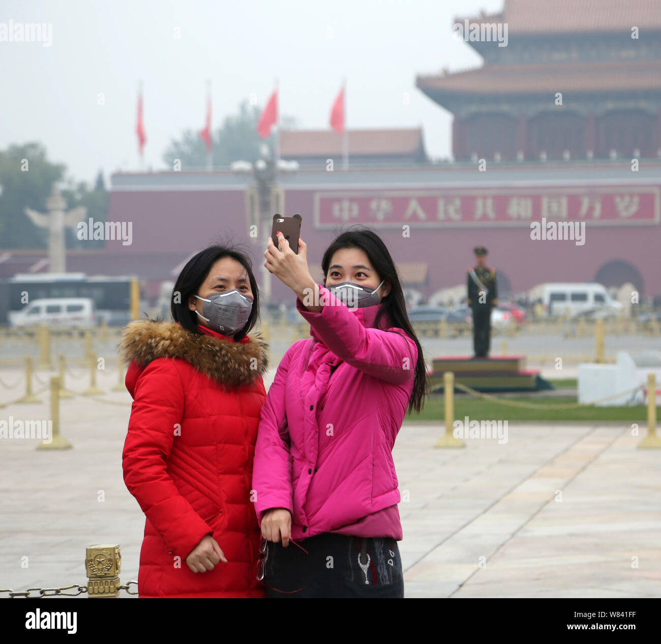 Tourists wearing face masks against air pollution take a selfie on the ...