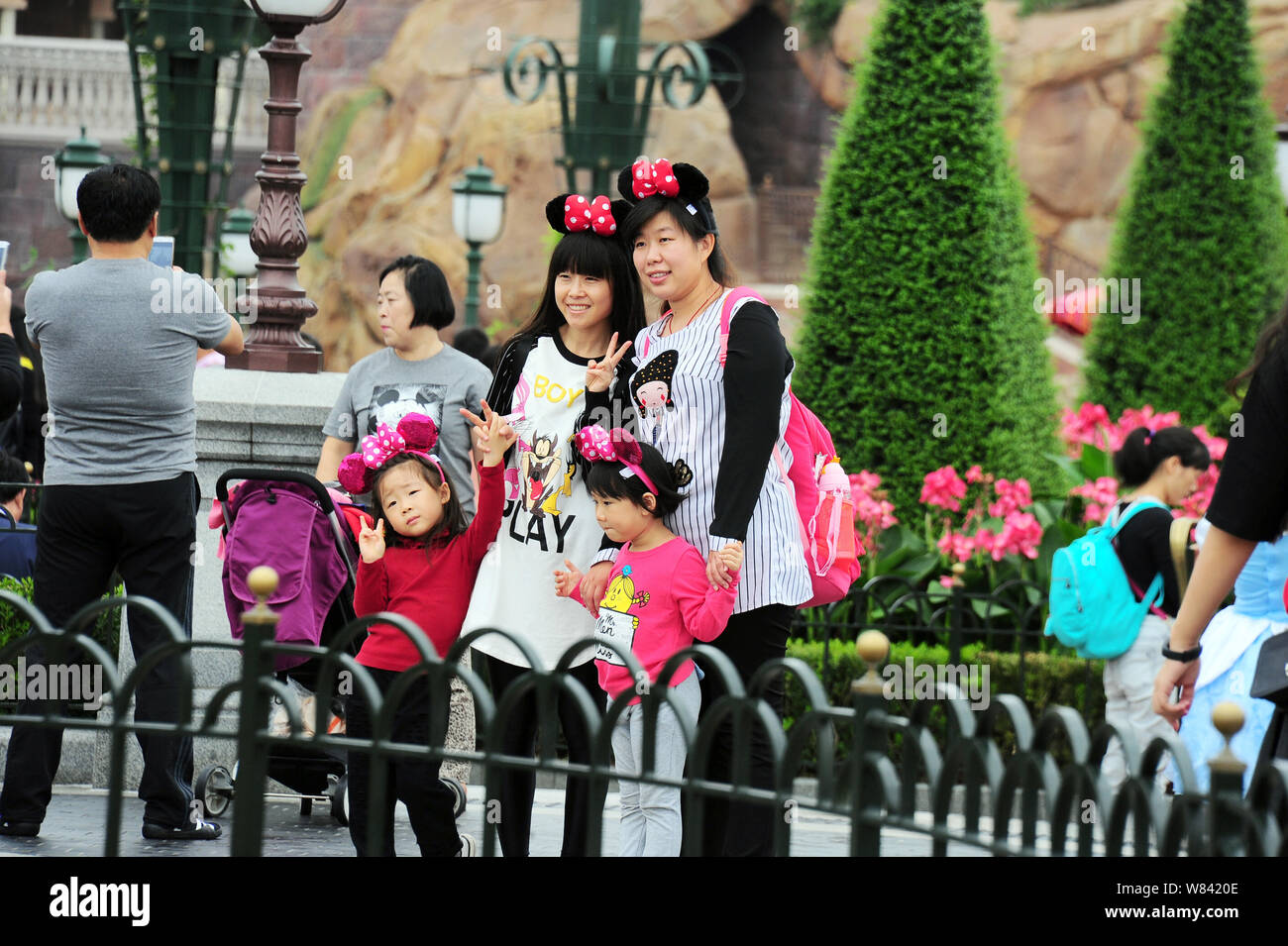 --FILE--Tourists wearing Mickey Mouse headwear pose for photos in the ...