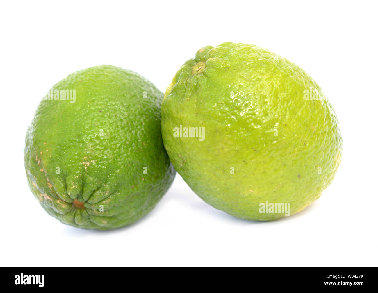 Two limes on white background Stock Photo - Alamy