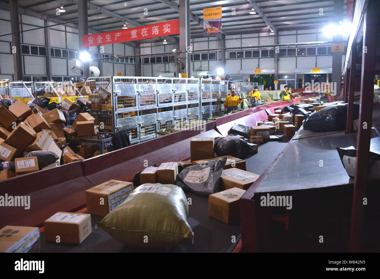 Chinese workers sort piles of parcels, most of which are from Singles ...