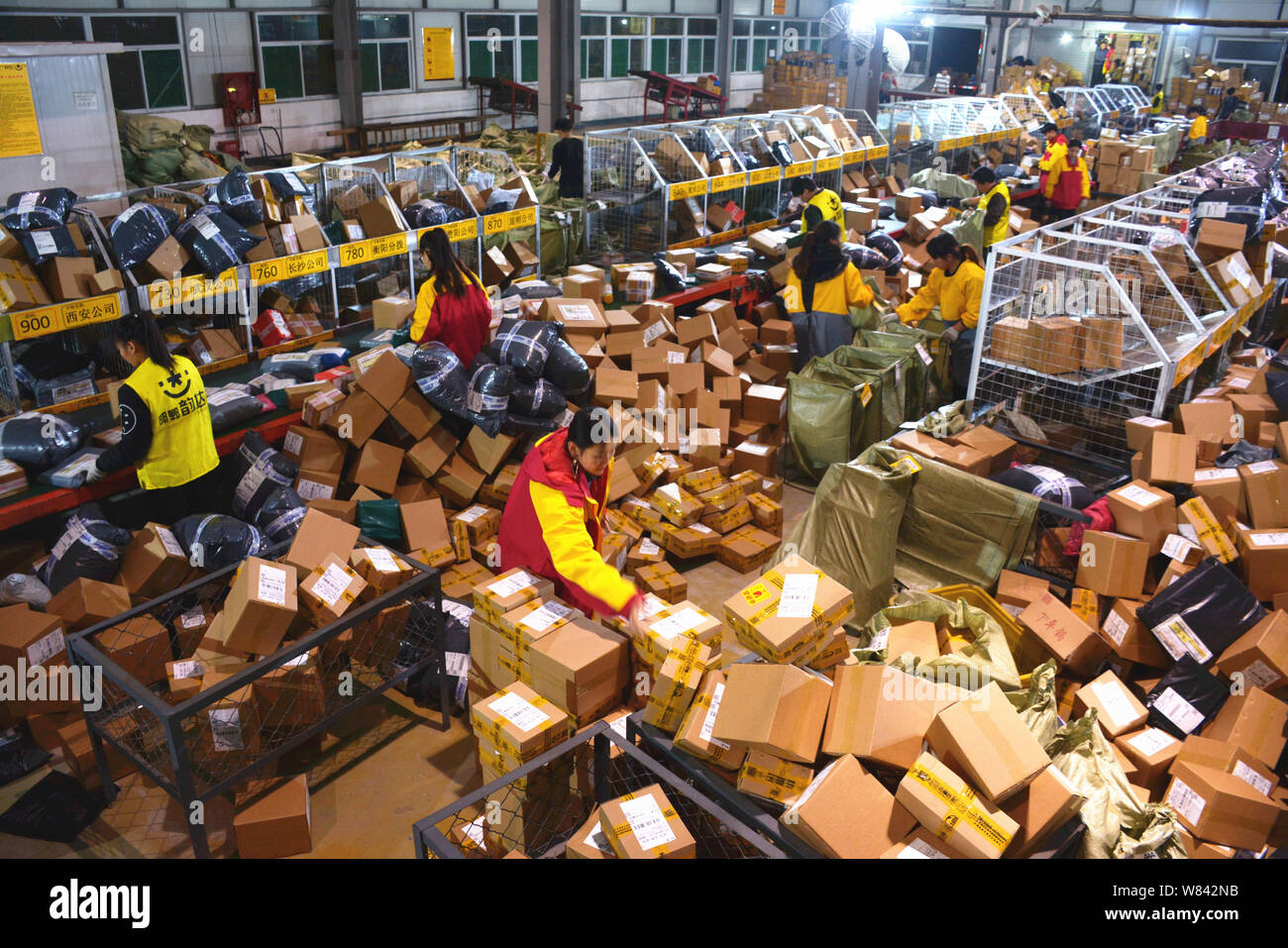 Chinese workers sort piles of parcels, most of which are from Singles Day online shopping, at a ...