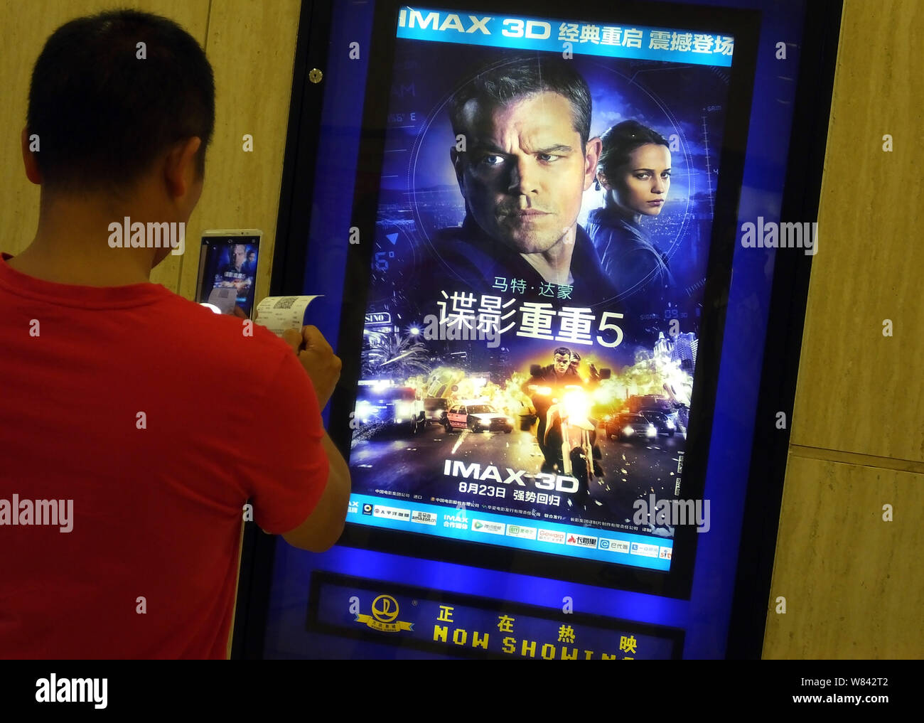 --FILE--A Chinese filmgoer takes a picture of a poster of the movie ...