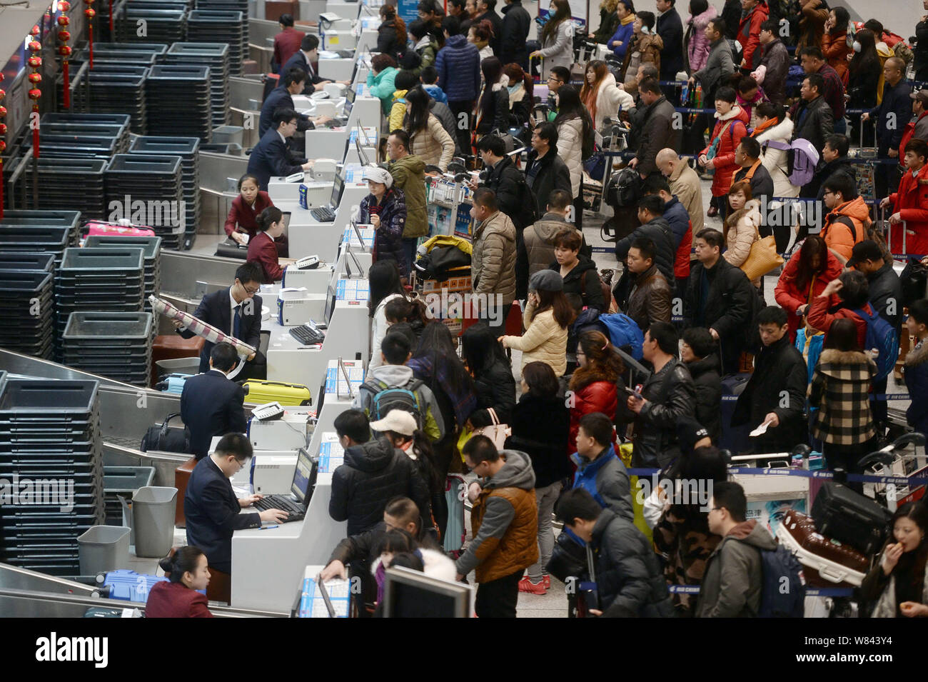 --FILE--Passengers queue up to get their boarding passes and have their ...