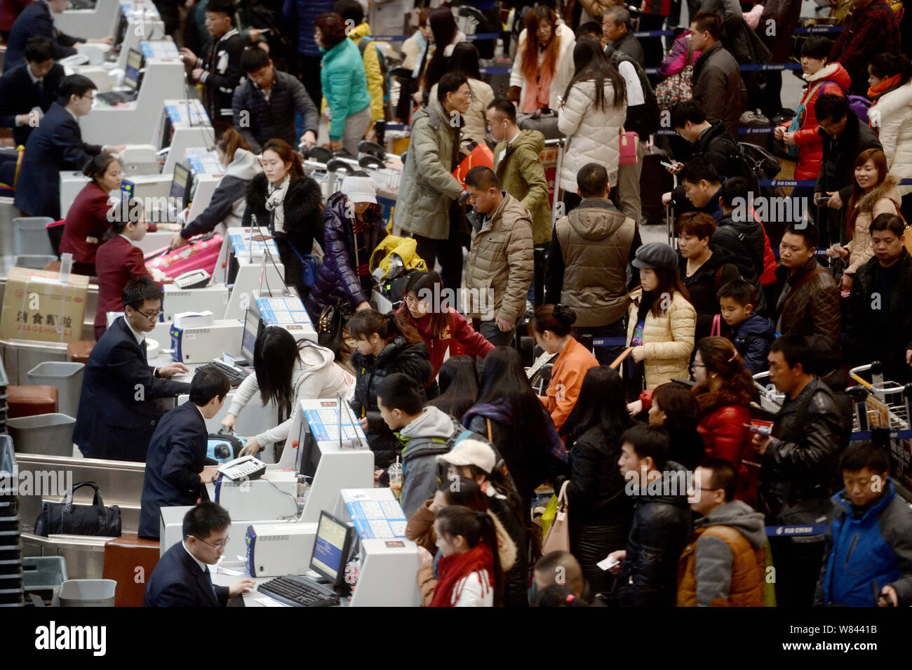 --FILE--Passengers queue up to get their boarding passes and have their ...