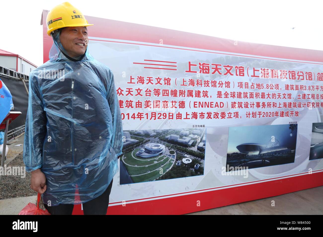 A Chinese worker stands next to a board showing an introduction of the ...