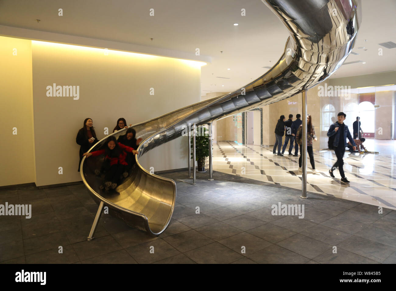 Chinese students try out a slide in the new library at Sias ...