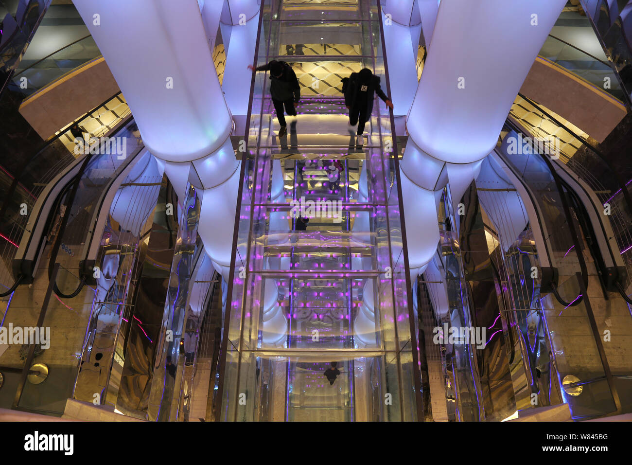 Chinese students walk through a glass bridge in the new library at Sias ...