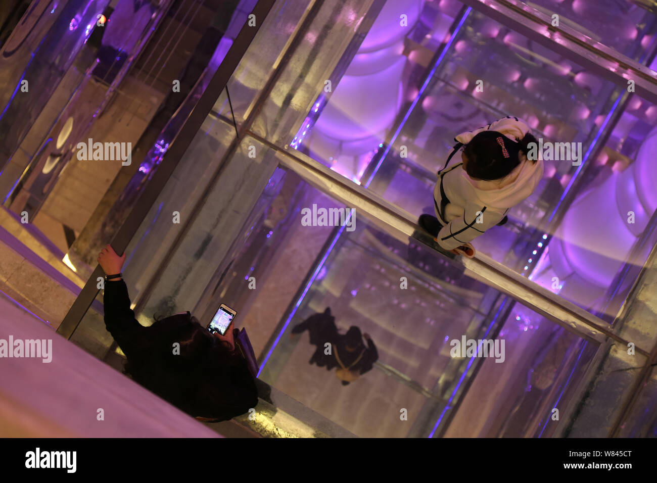 Chinese students walk through a glass bridge in the new library at Sias ...