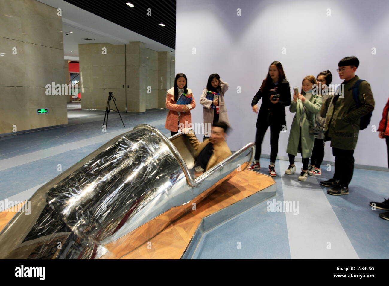 A Chinese student tries out a slide in the new library at Sias ...