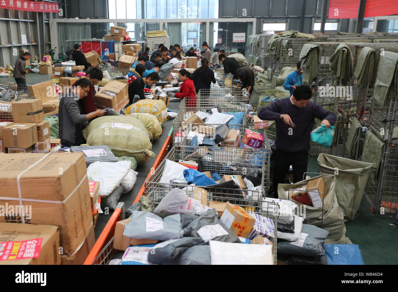 Chinese workers sort piles of parcels, most of which are from Singles Day online shopping, at a ...