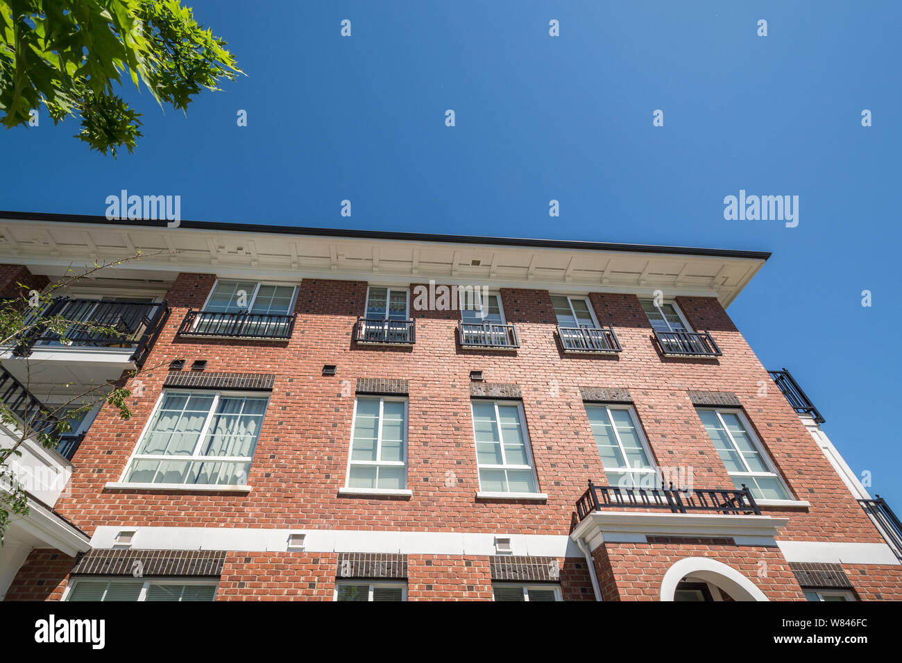 Top of new brick apartment building on blue sky background in British ...