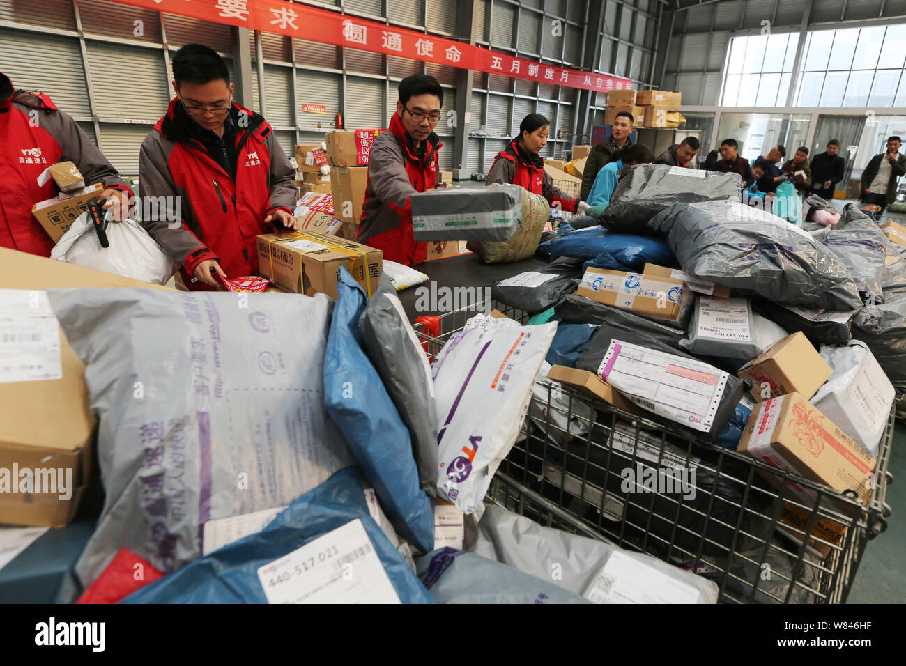 Chinese workers sort piles of parcels, most of which are from Singles Day online shopping, at a ...
