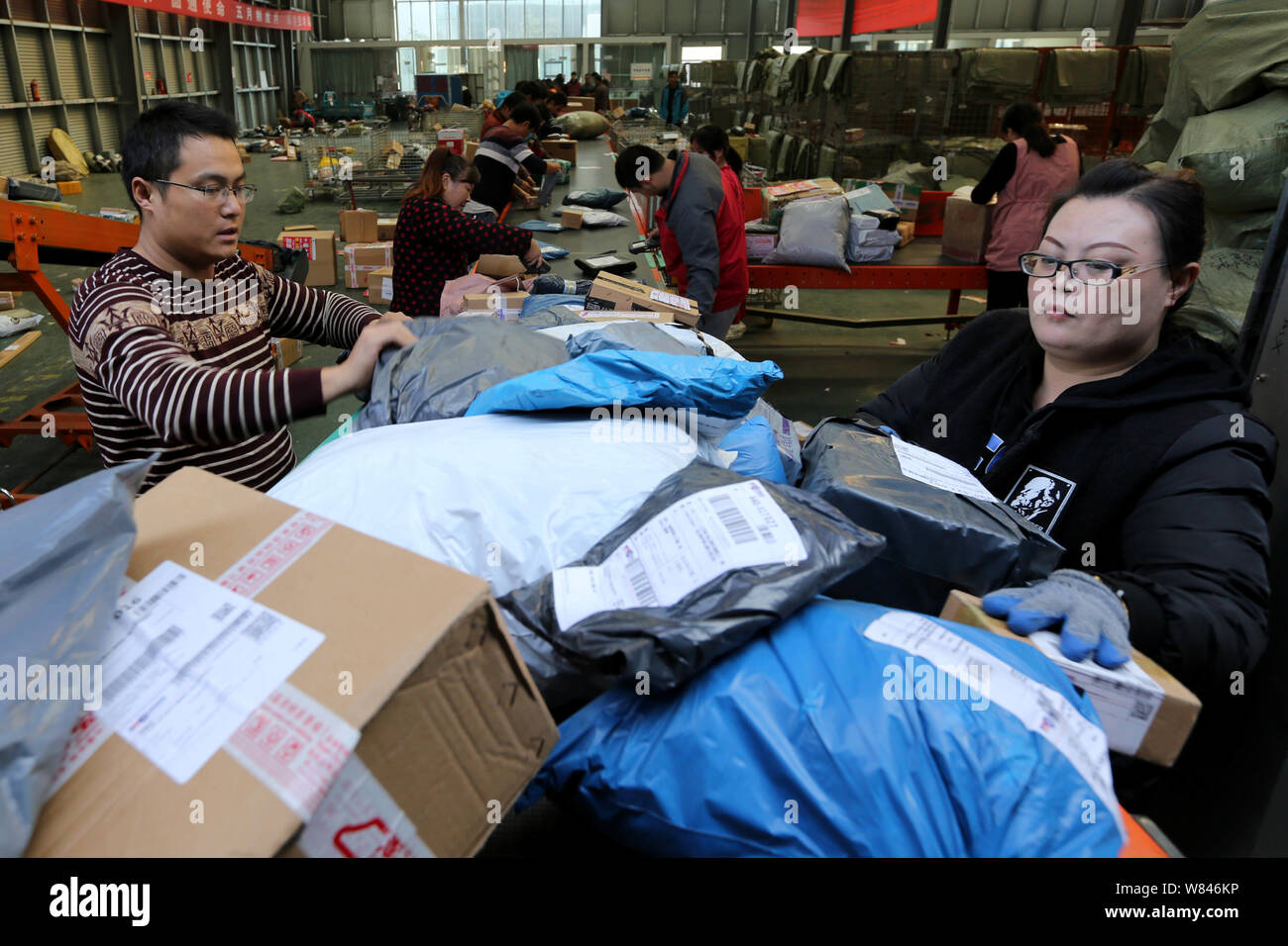 Chinese workers sort piles of parcels, most of which are from Singles ...