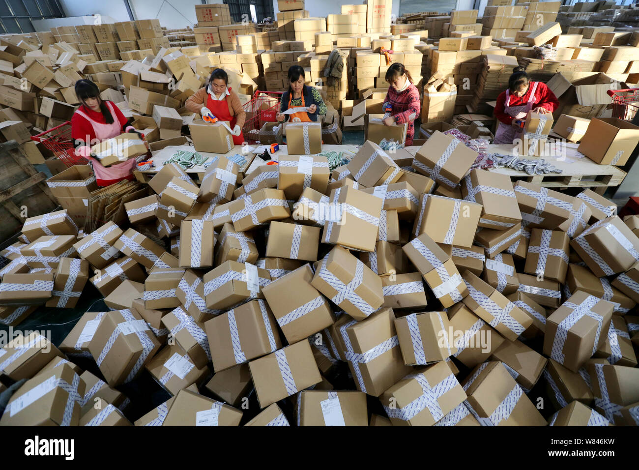 Chinese workers sort piles of parcels, most of which are from Singles ...