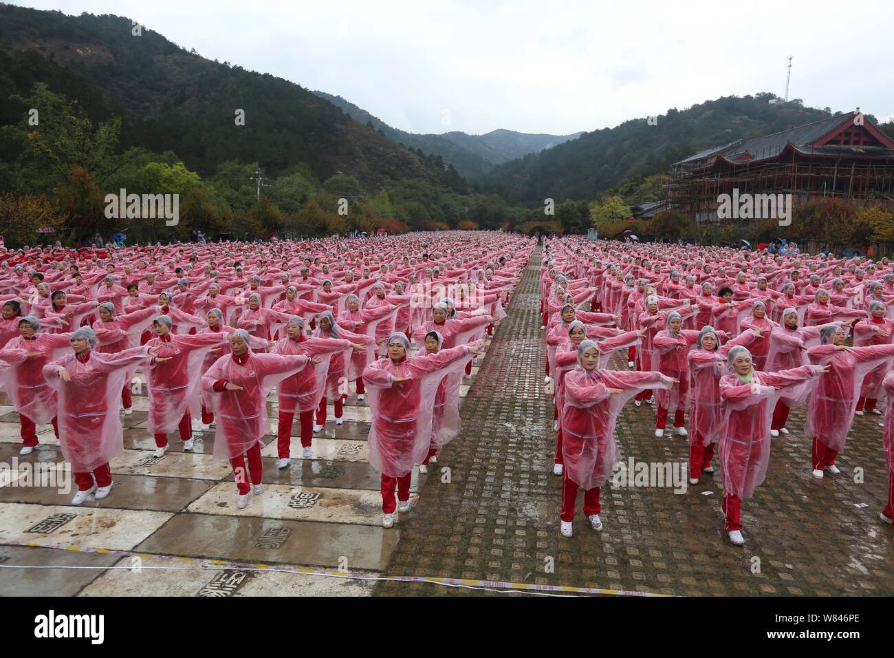 Local Chinese residents wearing raincoats perform square dance in the ...