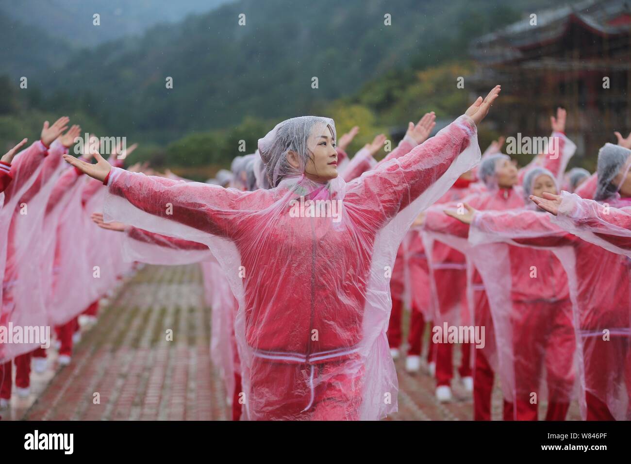Local Chinese residents wearing raincoats perform square dance in the ...