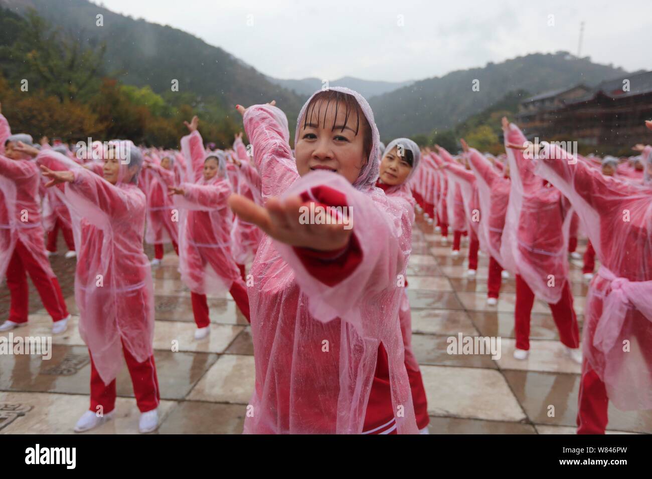 Local Chinese residents wearing raincoats perform square dance in the ...